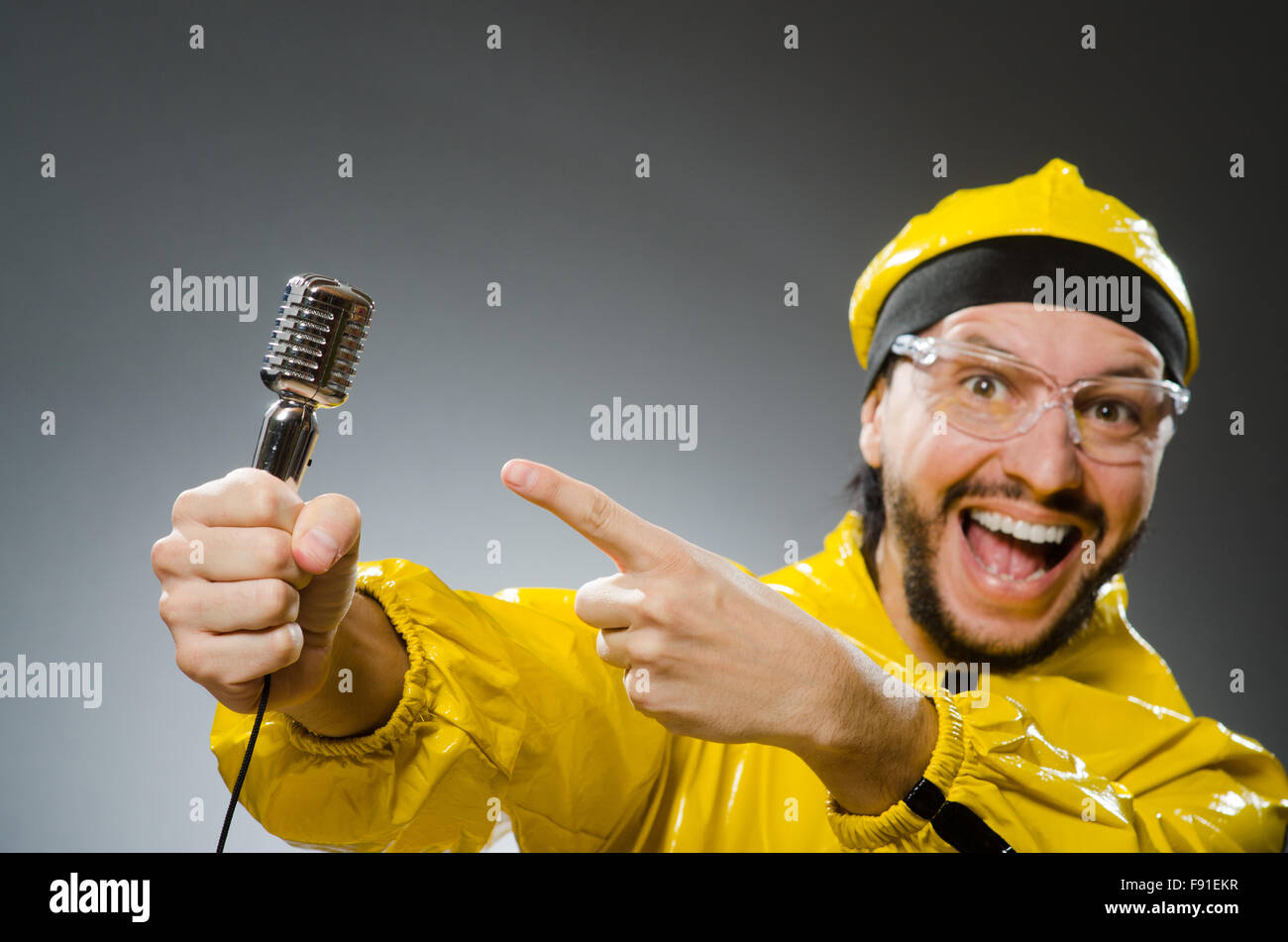 Man wearing yellow suit with mic Stock Photo - Alamy