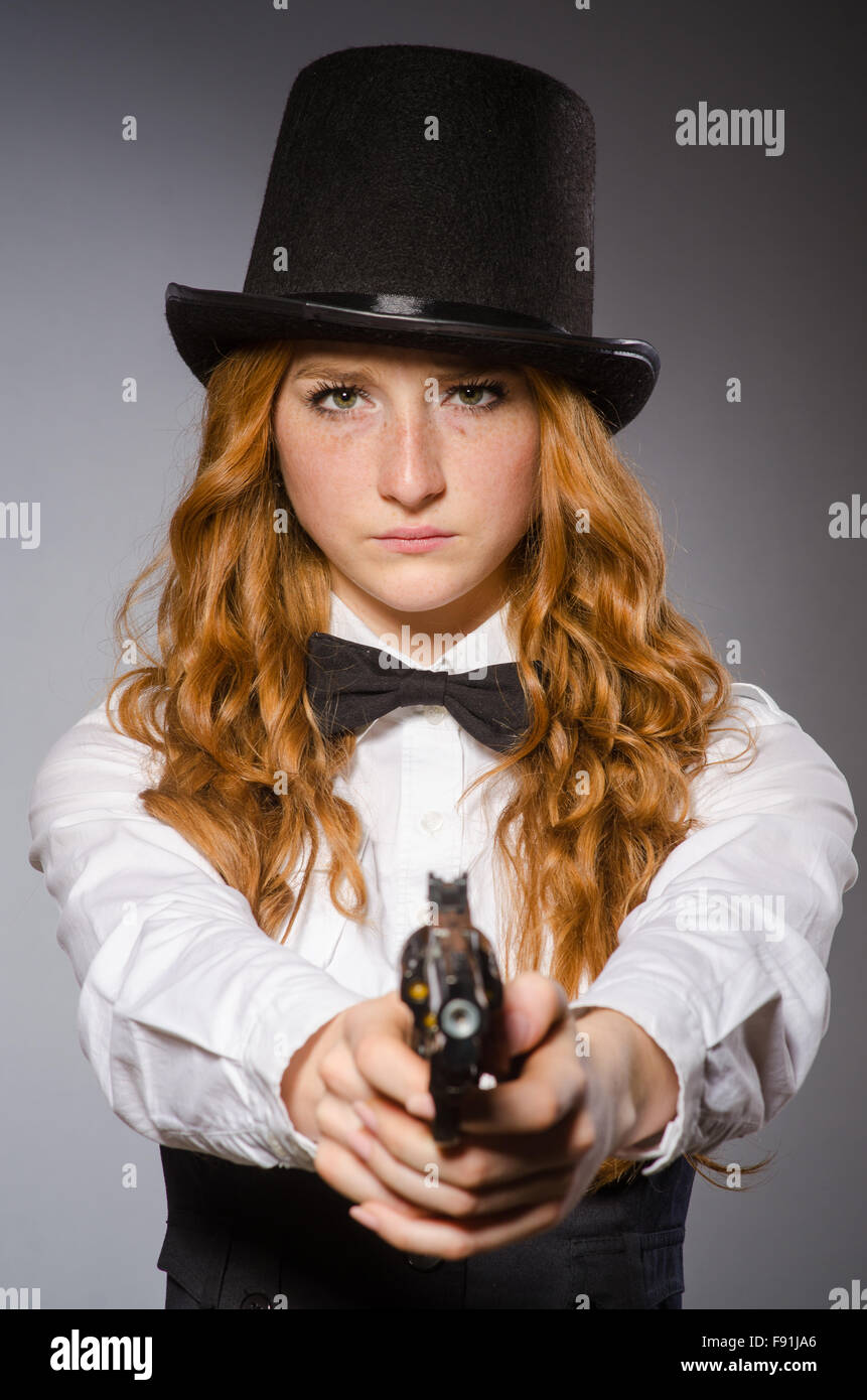 Pretty girl wearing retro hat and holding weapon isolated on gray Stock ...