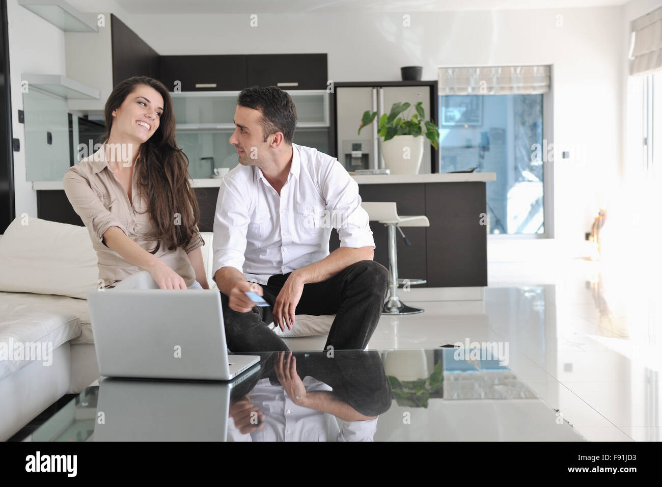 joyful couple relax and work on laptop computer at modern living room ...