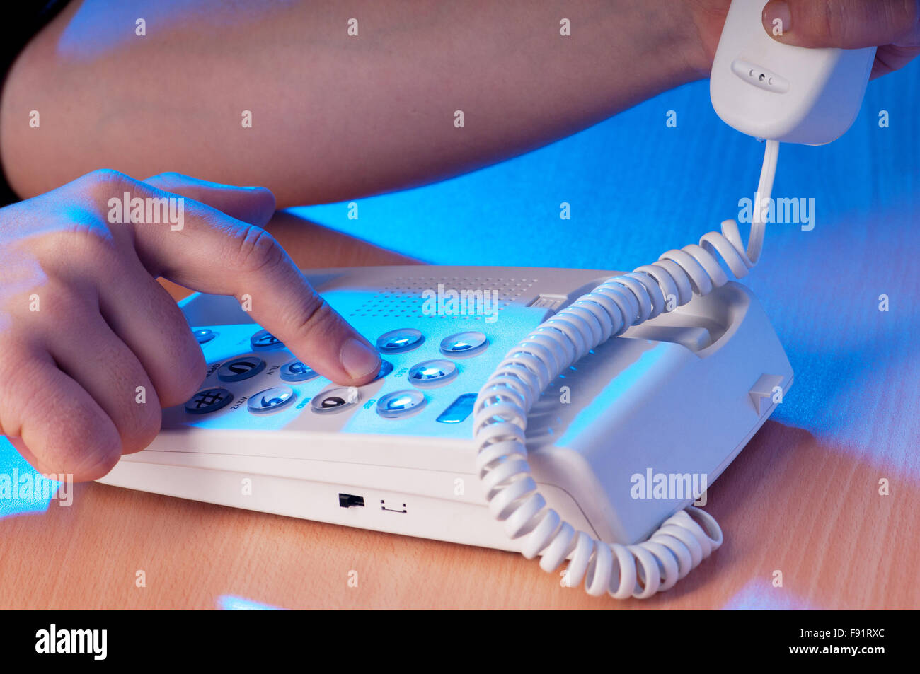Hands dialing phone buttons in the darkness Stock Photo - Alamy