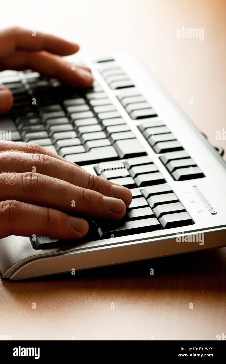 Two hands working on the silver keyboard Stock Photo - Alamy