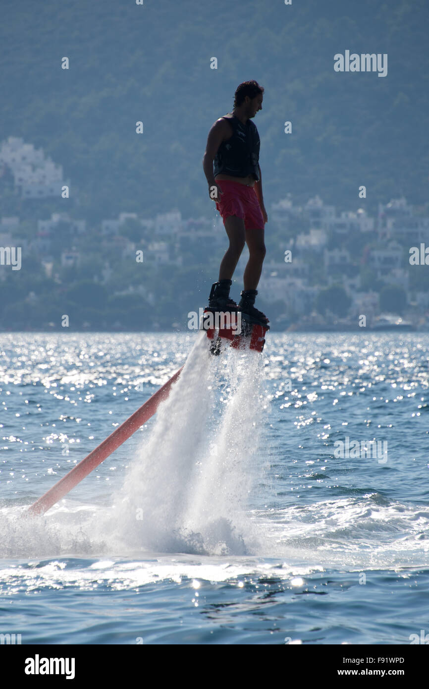 Flyboarder in silhouette flying over backlit sea Stock Photo - Alamy