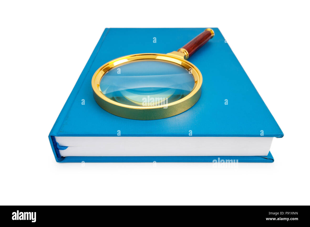 Magnifying glass over the stack of books Stock Photo - Alamy