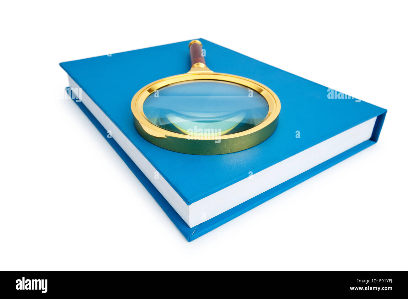 Magnifying glass over the stack of books Stock Photo - Alamy
