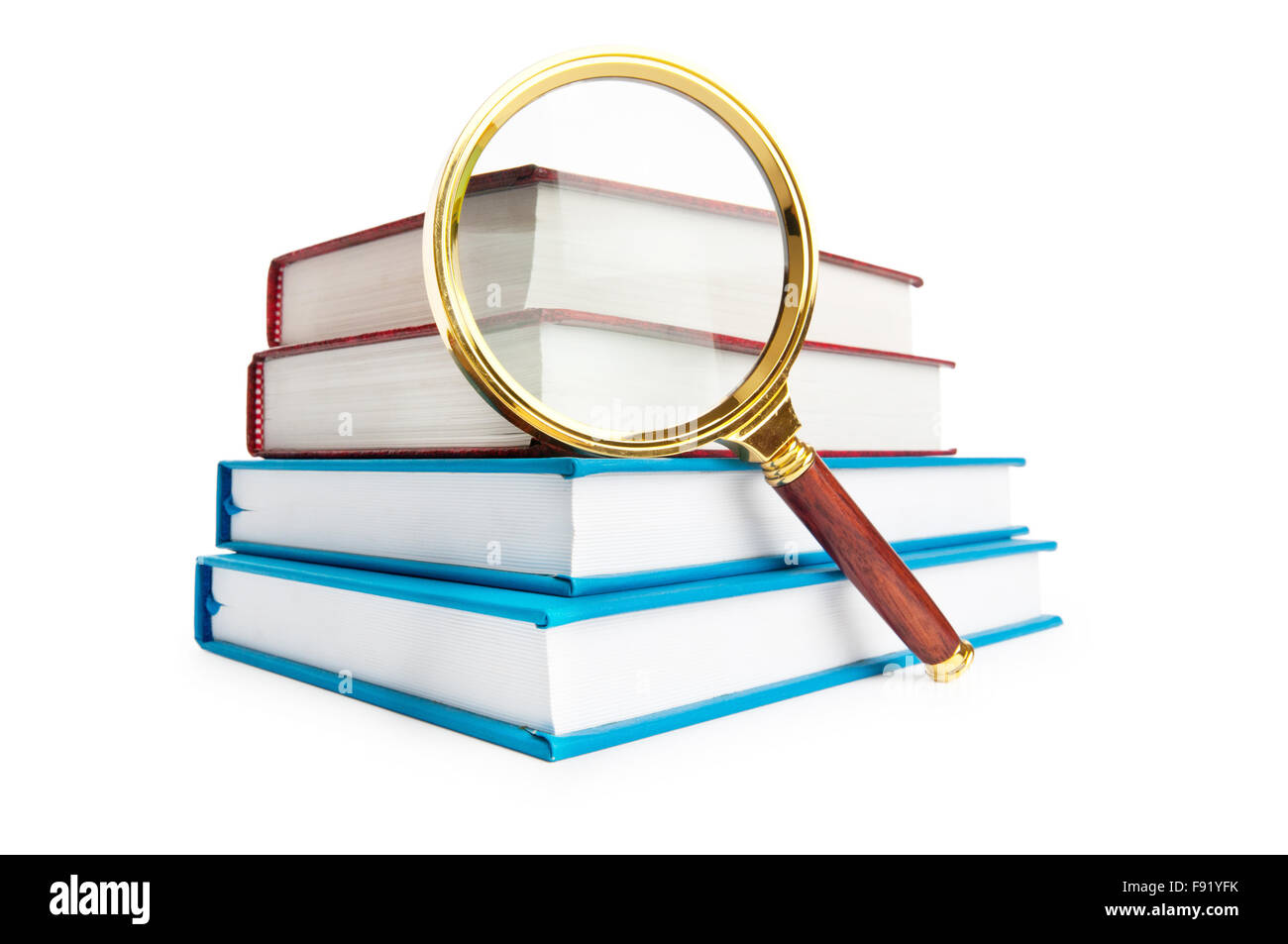 Magnifying glass over the stack of books Stock Photo - Alamy