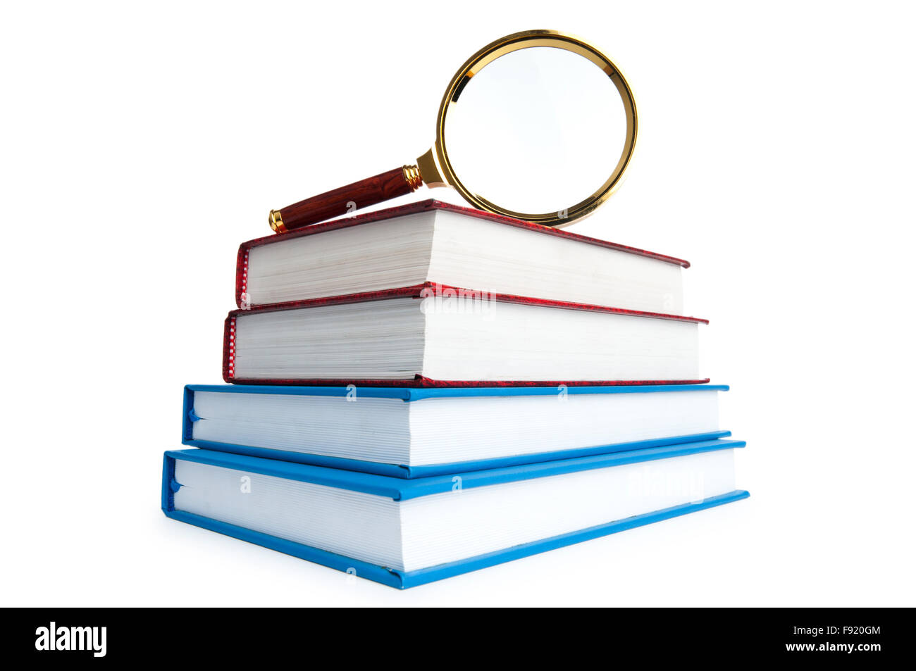 Magnifying glass over the stack of books Stock Photo - Alamy