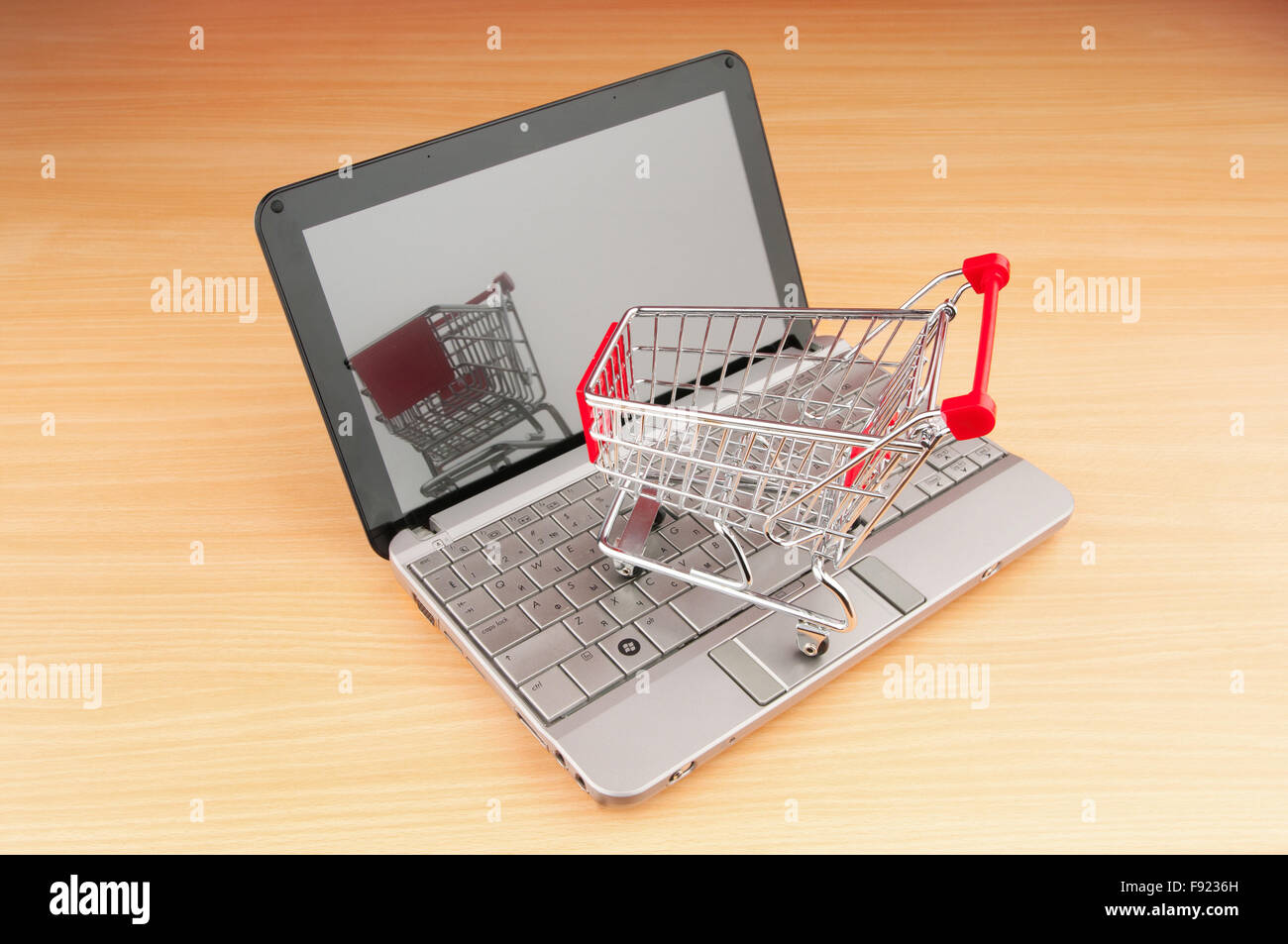 Shopping online with computer and cart Stock Photo - Alamy