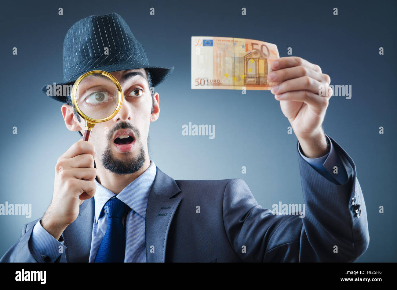 Detective looking at fake money Stock Photo - Alamy