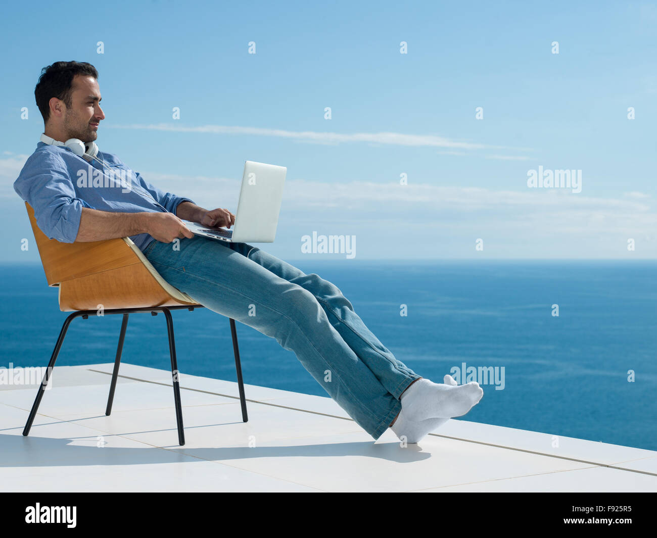 handsome young man relaxing and working on laptop computer at home ...