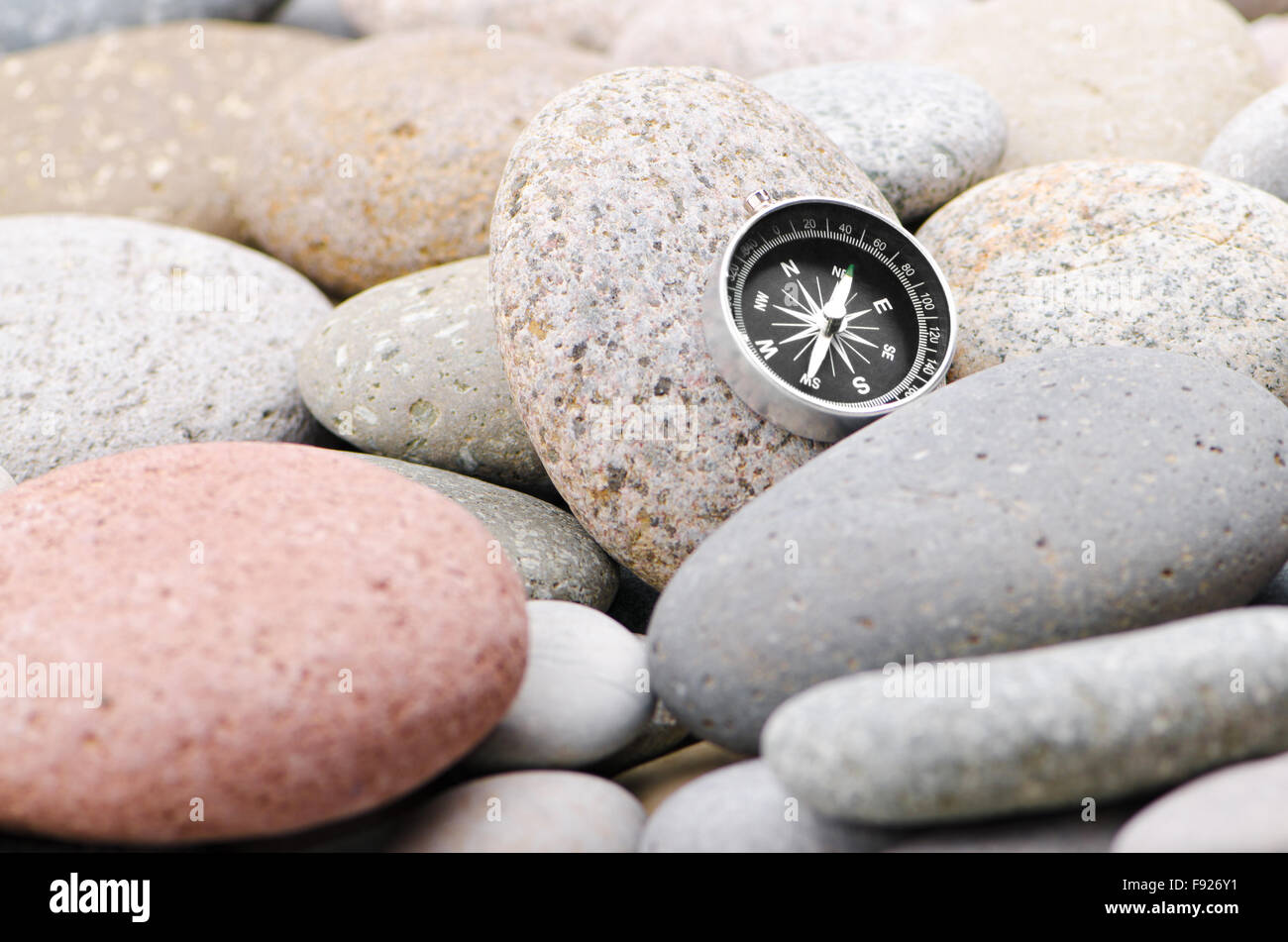 Navigation compass on stone pebbles Stock Photo - Alamy