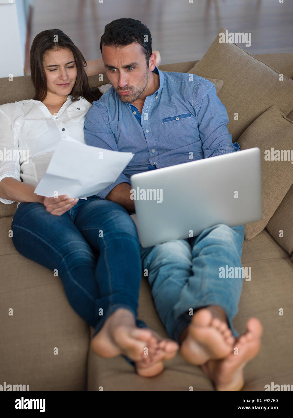 happy young relaxed couple working on laptop computer at modern home ...
