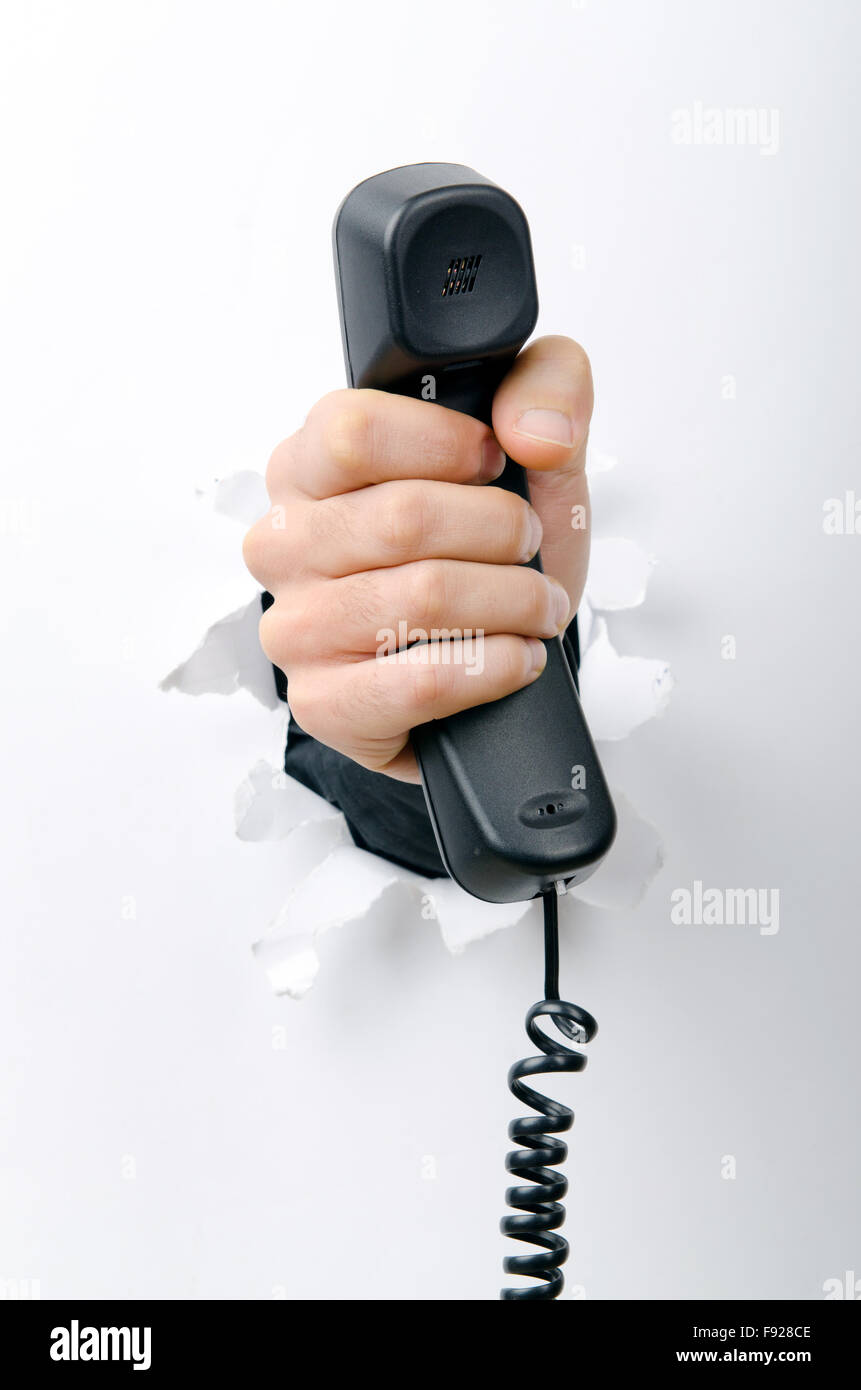 Hand holding phone through hole in paper Stock Photo - Alamy