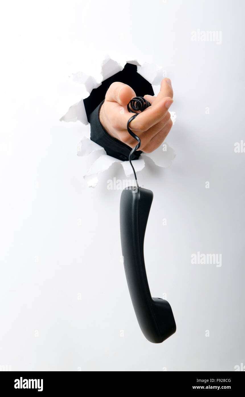 Hand holding phone through hole in paper Stock Photo - Alamy