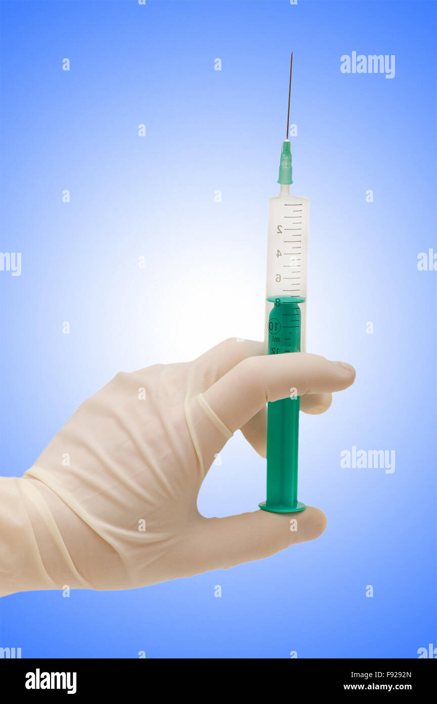 Hand holding syringe on gradient Stock Photo - Alamy