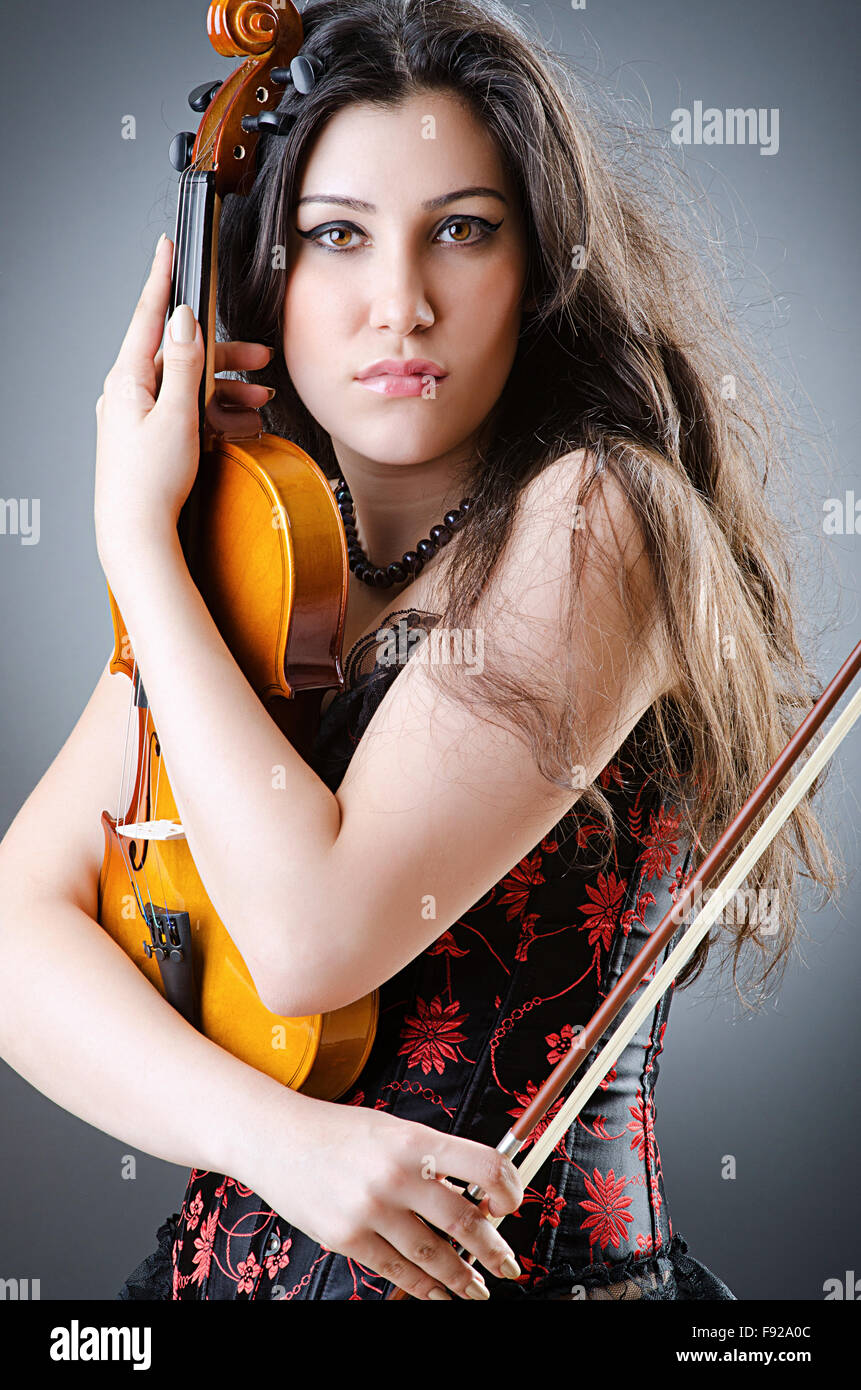 Female violin player against background Stock Photo - Alamy