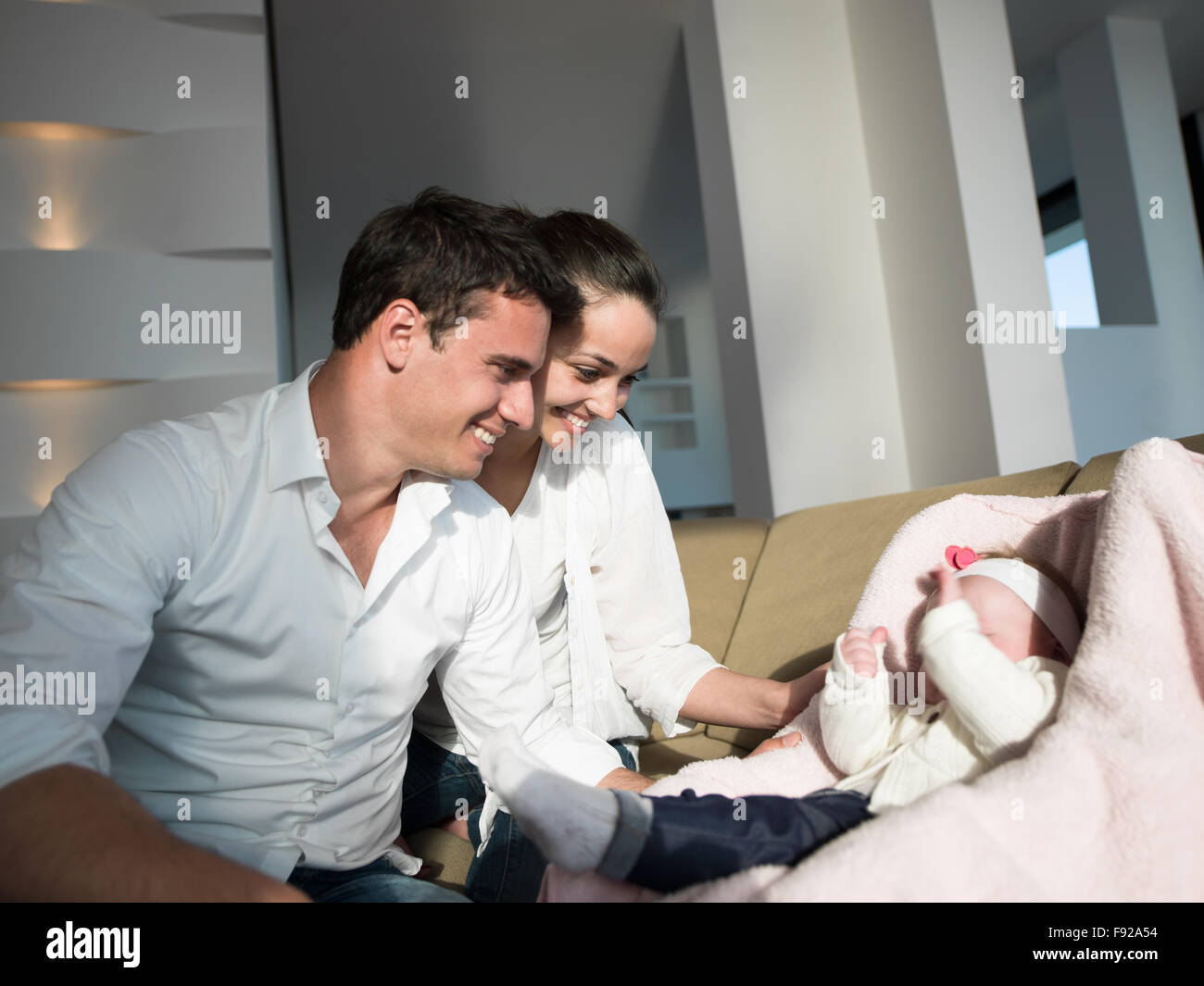 happy young family couple with beautiful new born baby have fun at ...