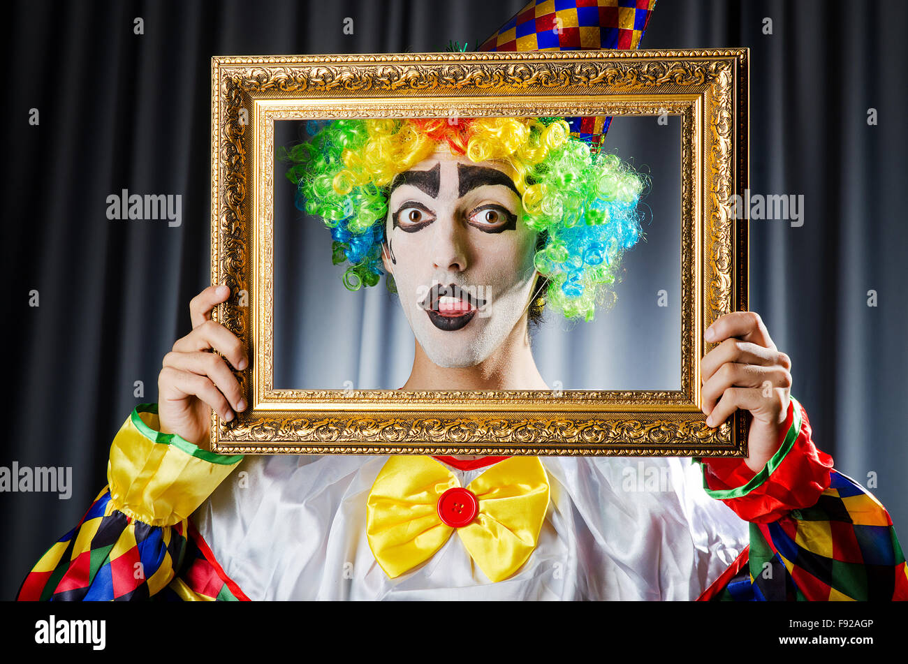 Clown with picture frames in studio Stock Photo - Alamy