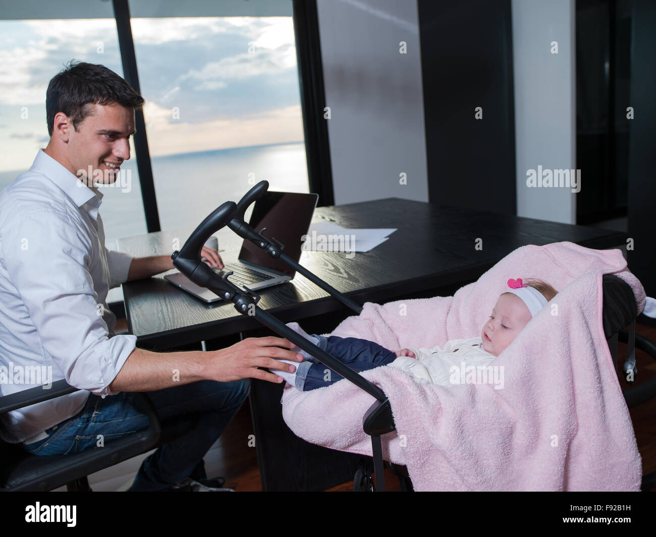 young man parent working on laptop computer at home office and take ...