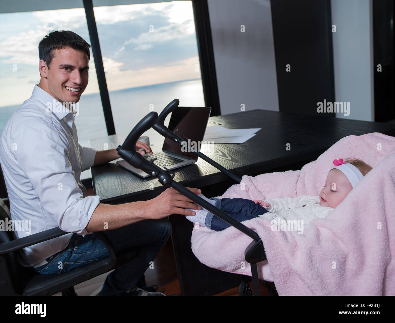 young man parent working on laptop computer at home office and take ...