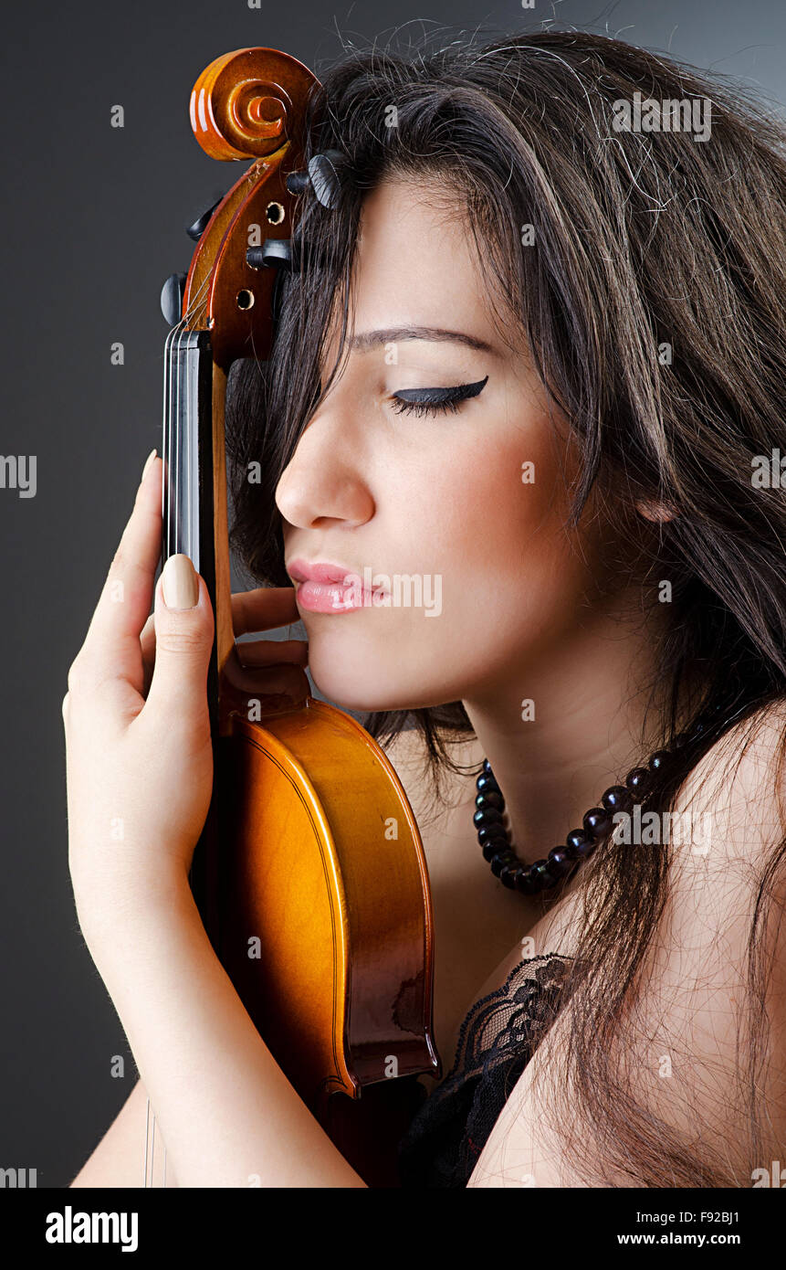 Female violin player against background Stock Photo - Alamy