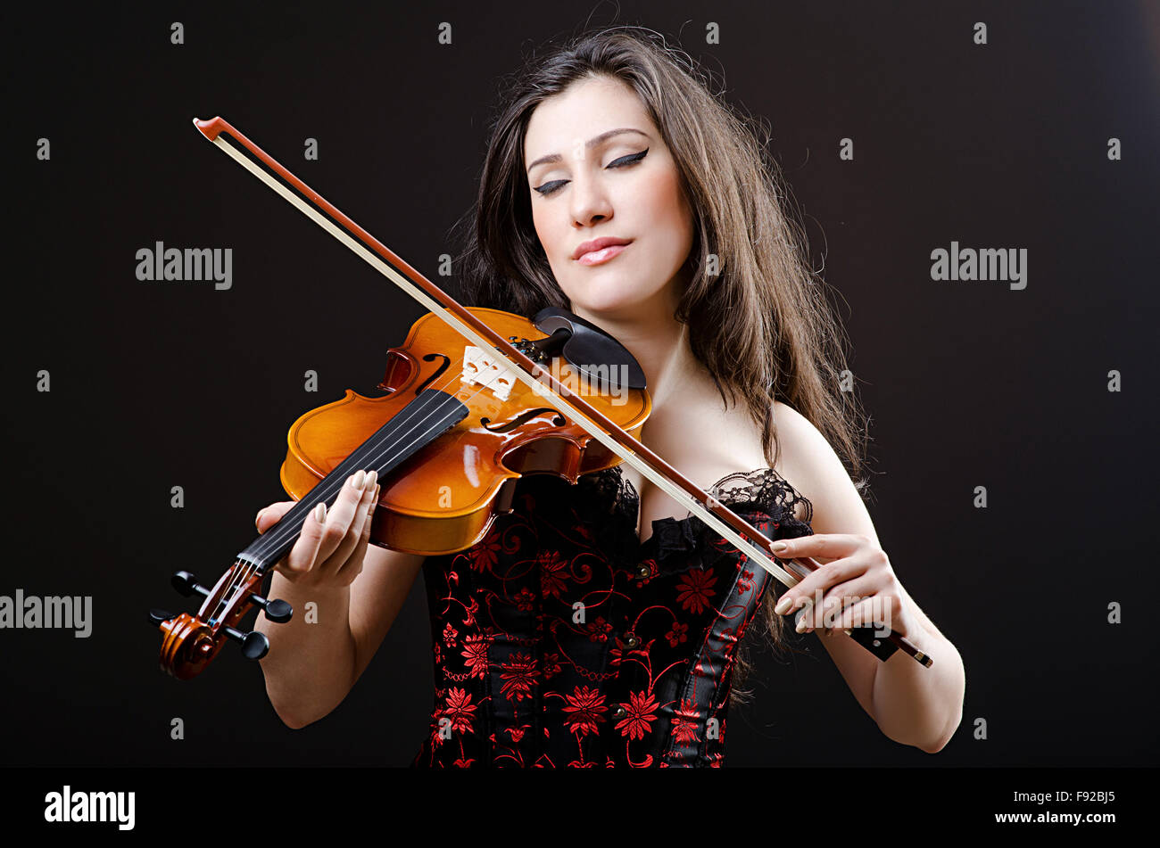 Female violin player against background Stock Photo - Alamy