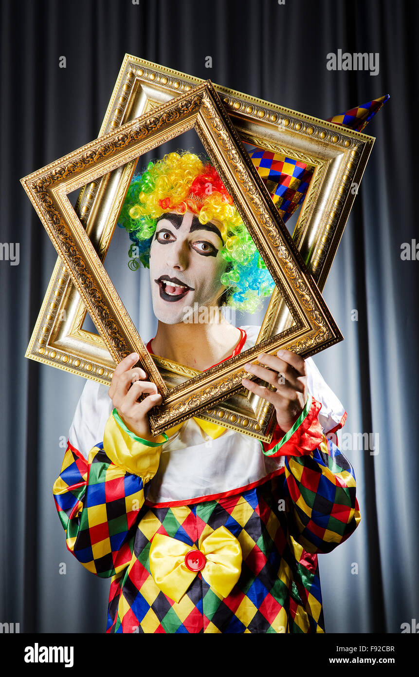 Clown with picture frames in studio Stock Photo - Alamy