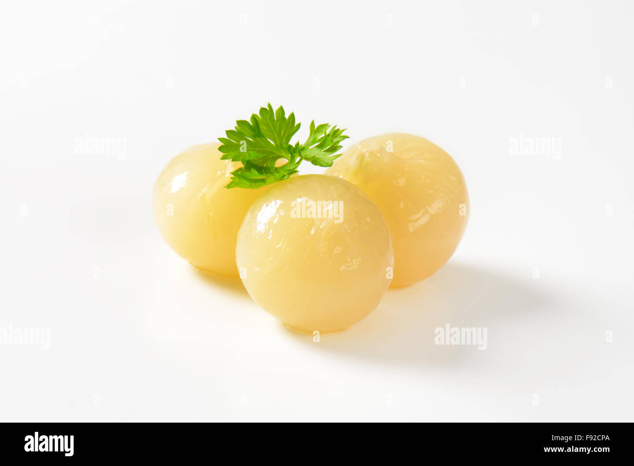 three small pickled onions on white background Stock Photo - Alamy