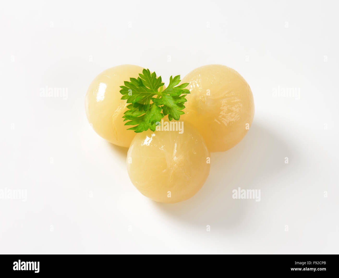 three small pickled onions on white background Stock Photo - Alamy