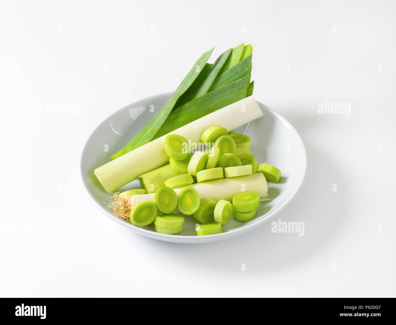 plate of sliced leek on white background Stock Photo - Alamy