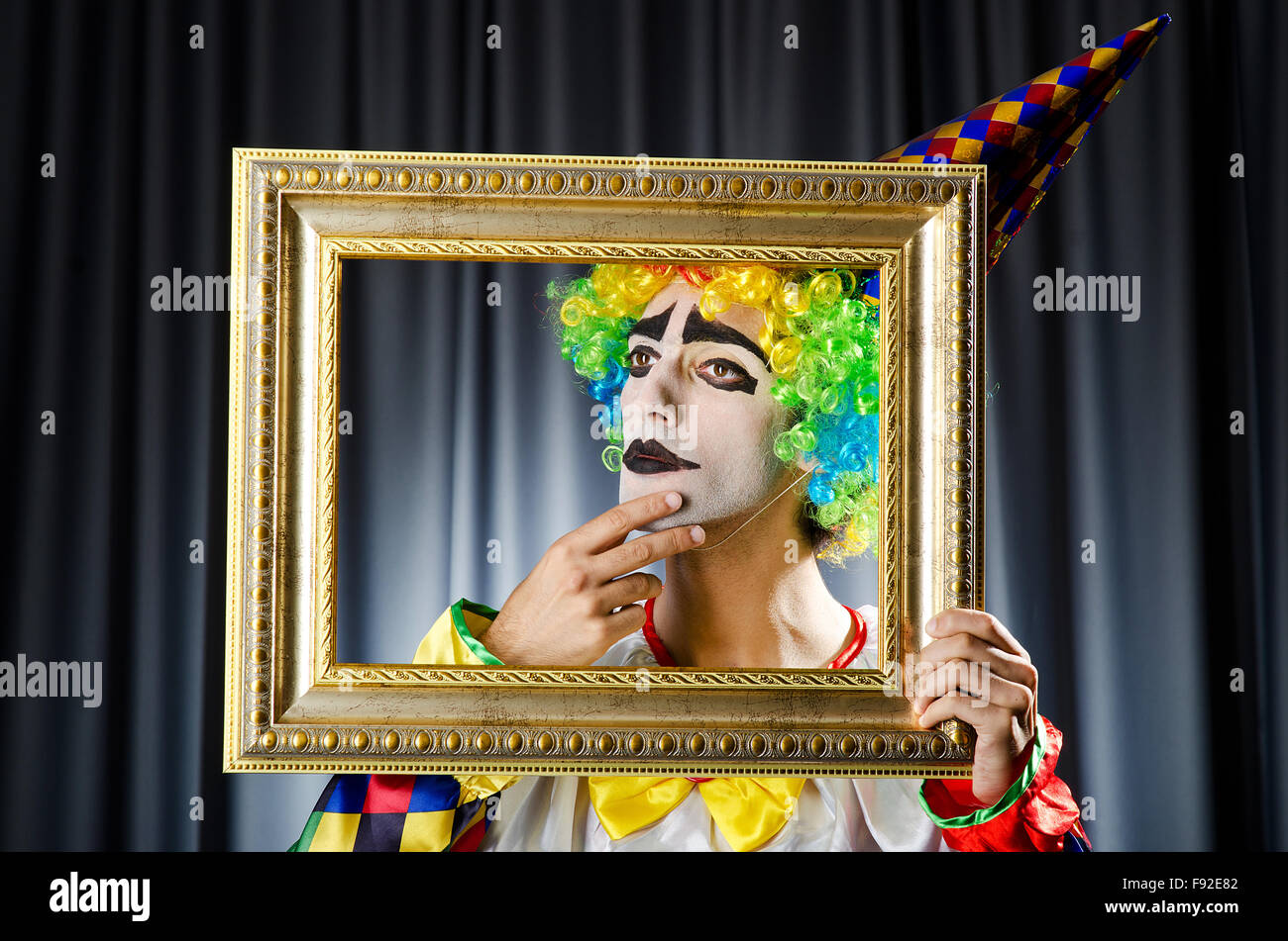Clown with picture frames in studio Stock Photo - Alamy
