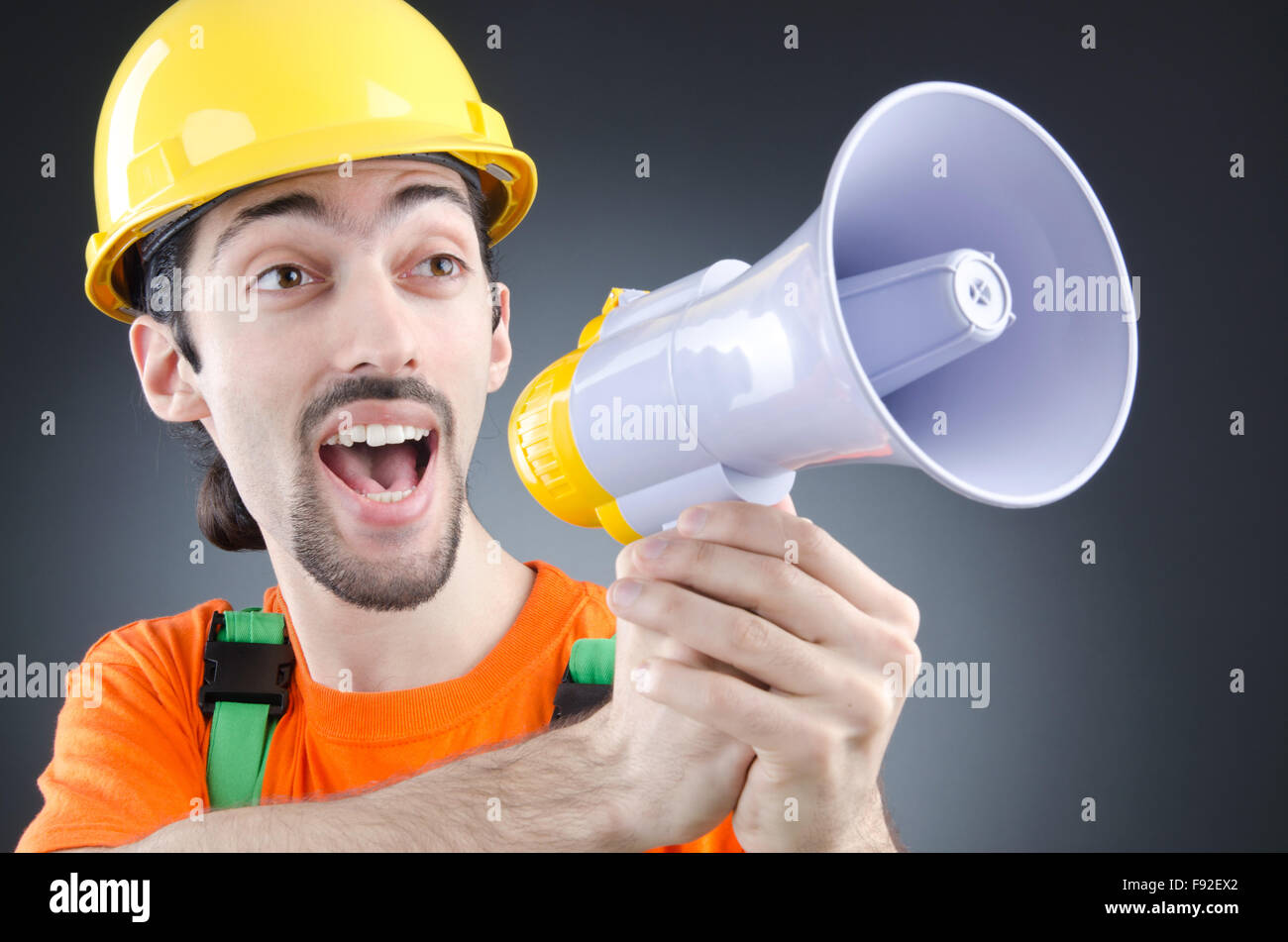 Construction worker with loudspeaker in studio Stock Photo - Alamy