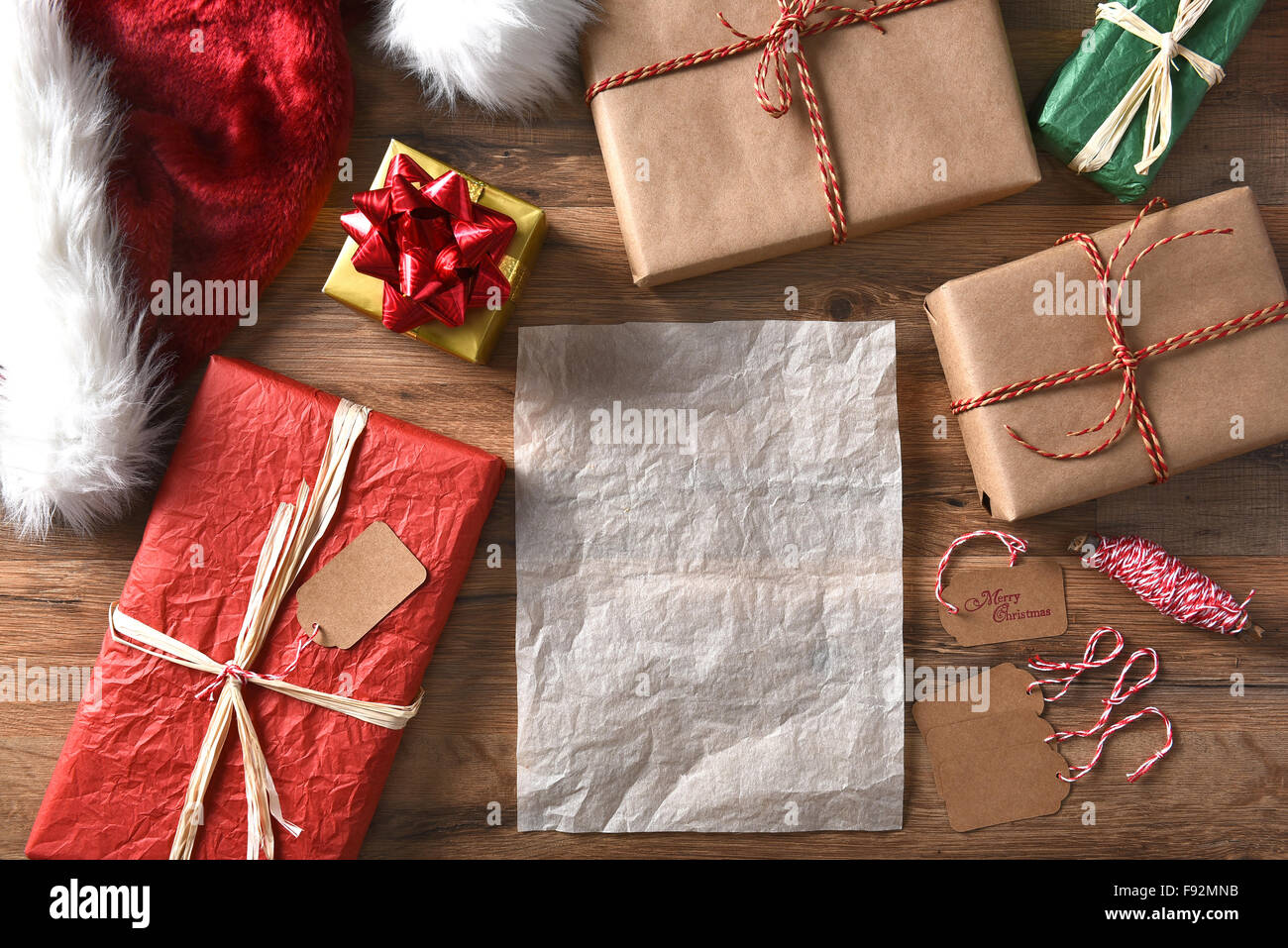 Overhead view of wrapped Christmas presents on a rustic wood table with ...