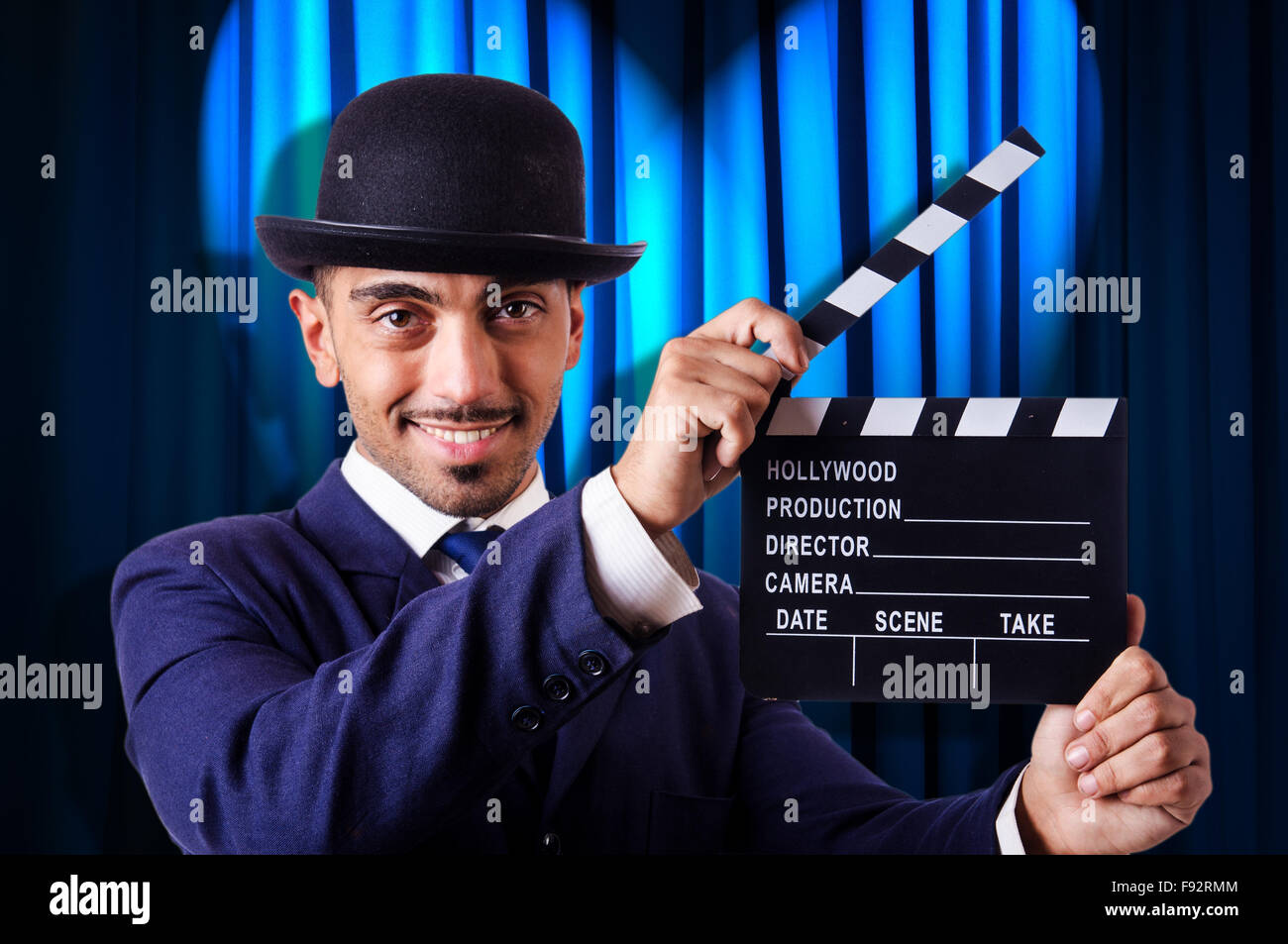 Man with movie clapper on curtain background Stock Photo - Alamy