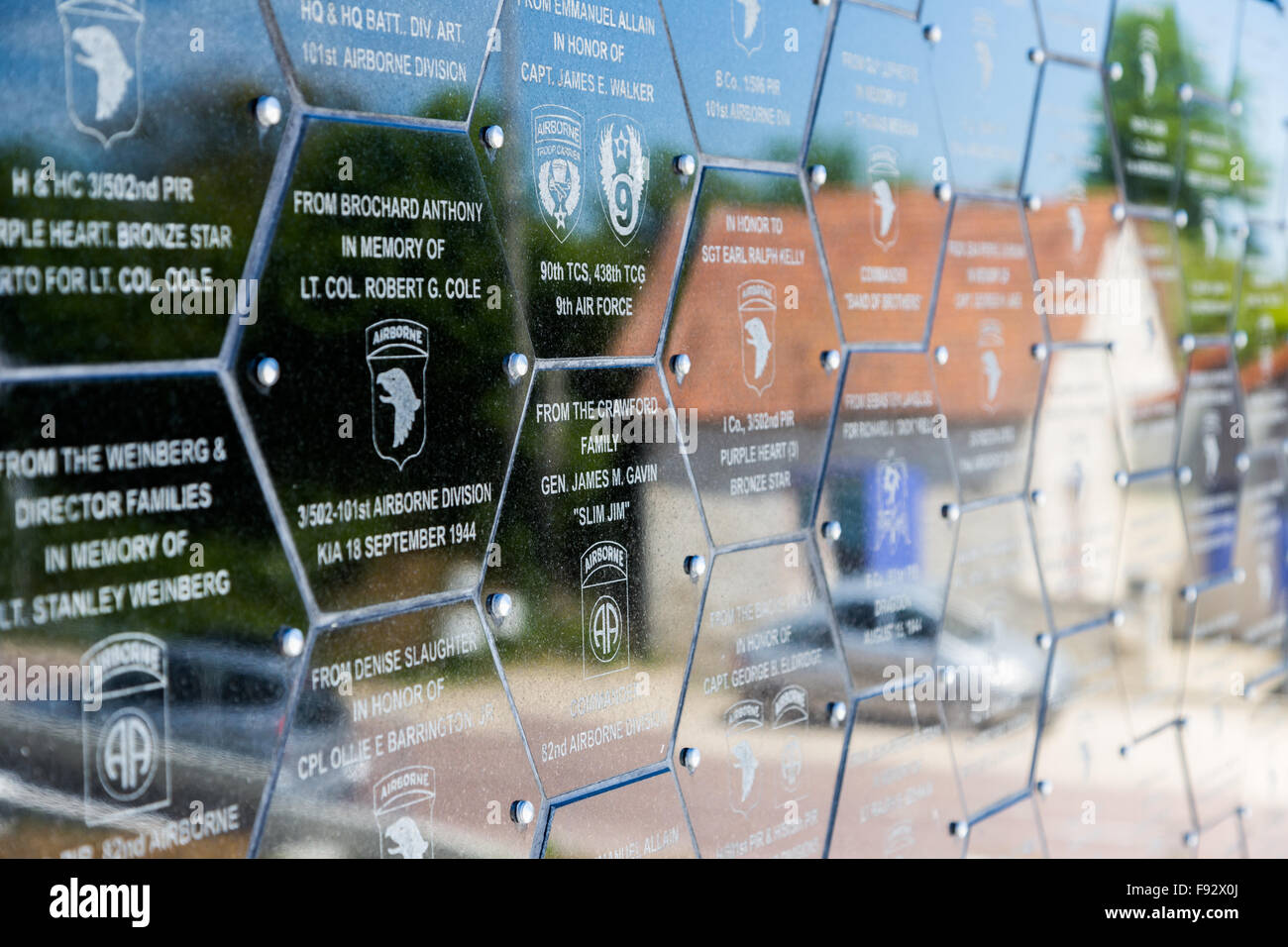Tribute commemorative name plates on a WW2 memorial wall in Carentan at ...