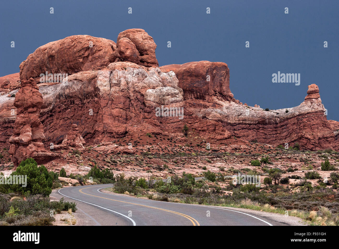 Curvy road, Arches Scenic Drive, Rock Pinnacles behind, thunderclouds ...