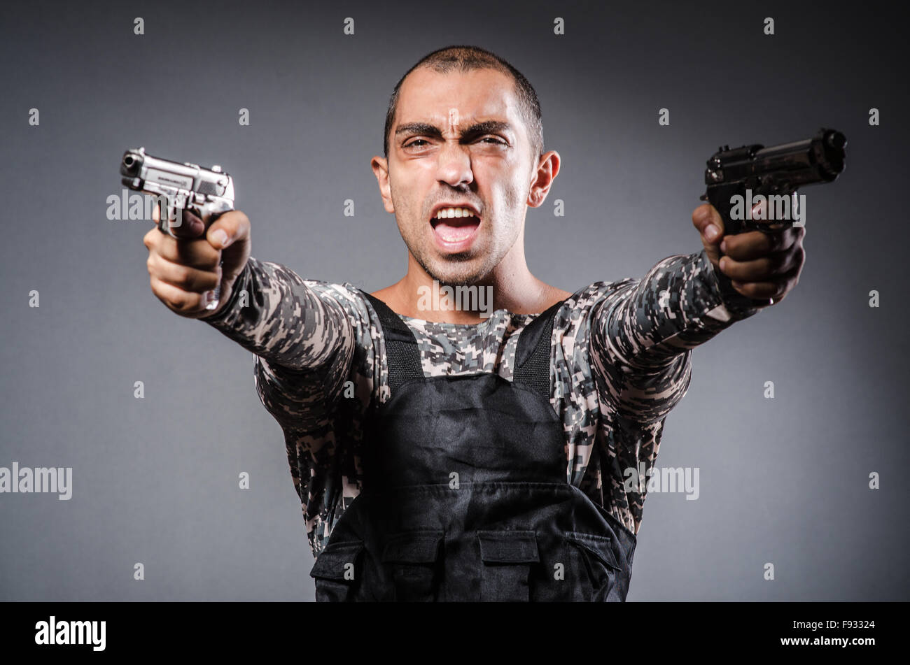 Soldier with guns against dark background Stock Photo - Alamy