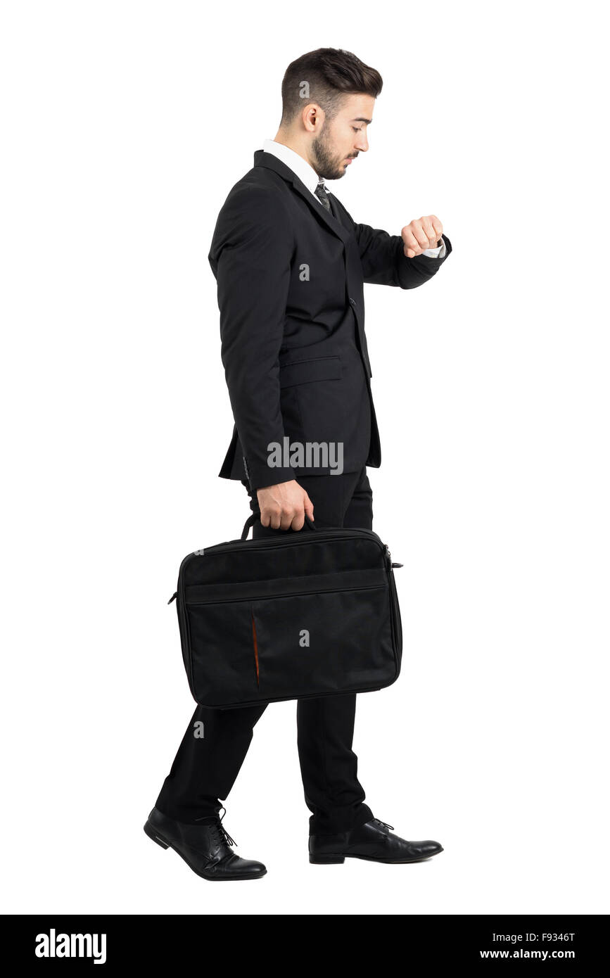 Side view of walking businessman checking hand watch time. Full body ...
