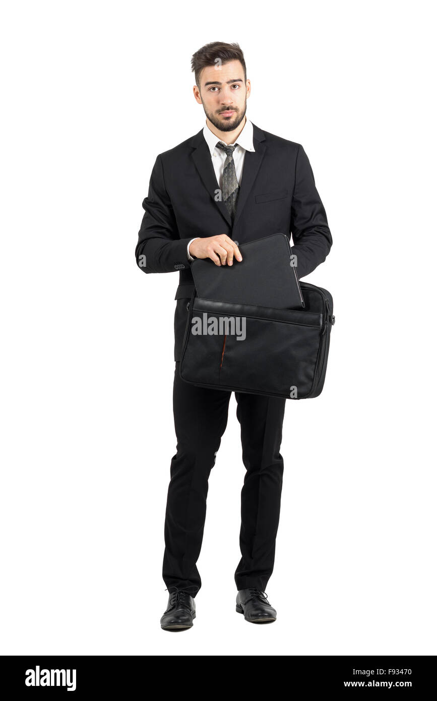Serious salesman taking document file out of briefcase looking at ...