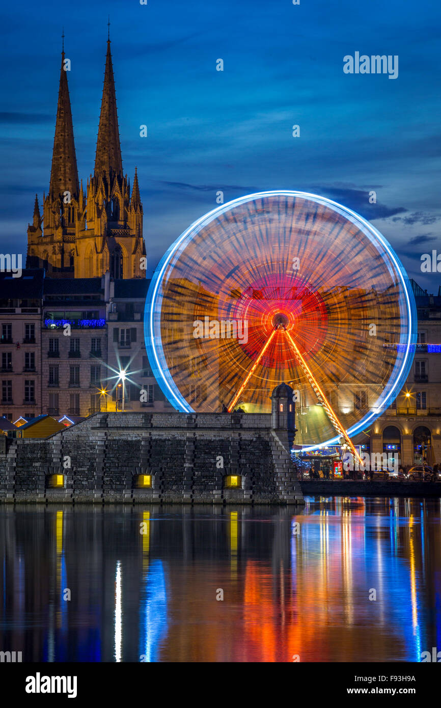 At night, a big wheel (Ferris Wheel) reflecting in water at the Adour ...