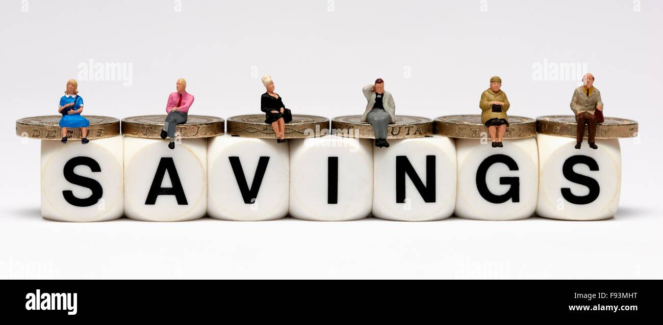 Miniature people sitting on one pound coins above the word savings ...