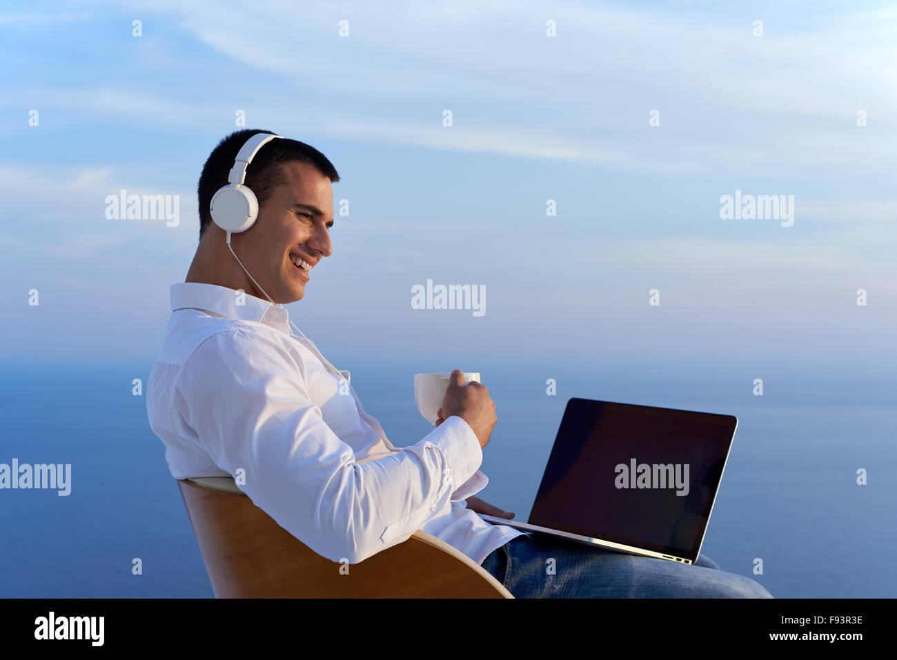 handsome young man relaxing and working on laptop computer at home ...