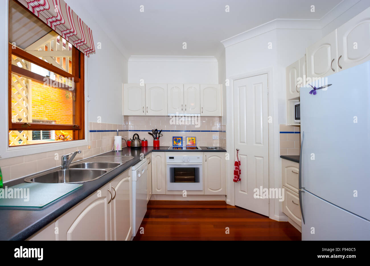 Small modern kitchen with a fridge, a stove, an oven and a sink; all in ...