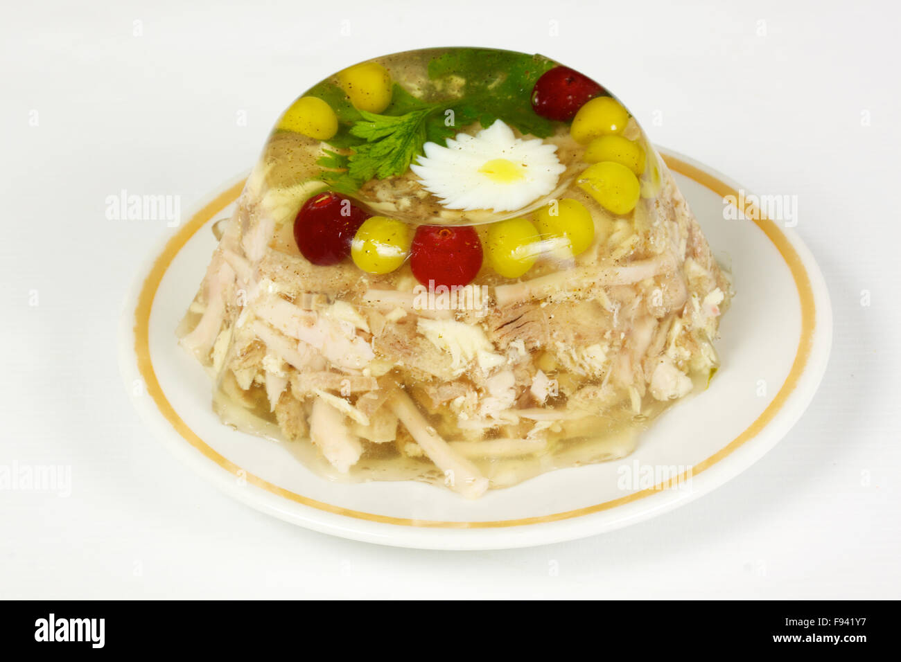 Aspic from chicken meat decorated with eggs and parsley on the white ...
