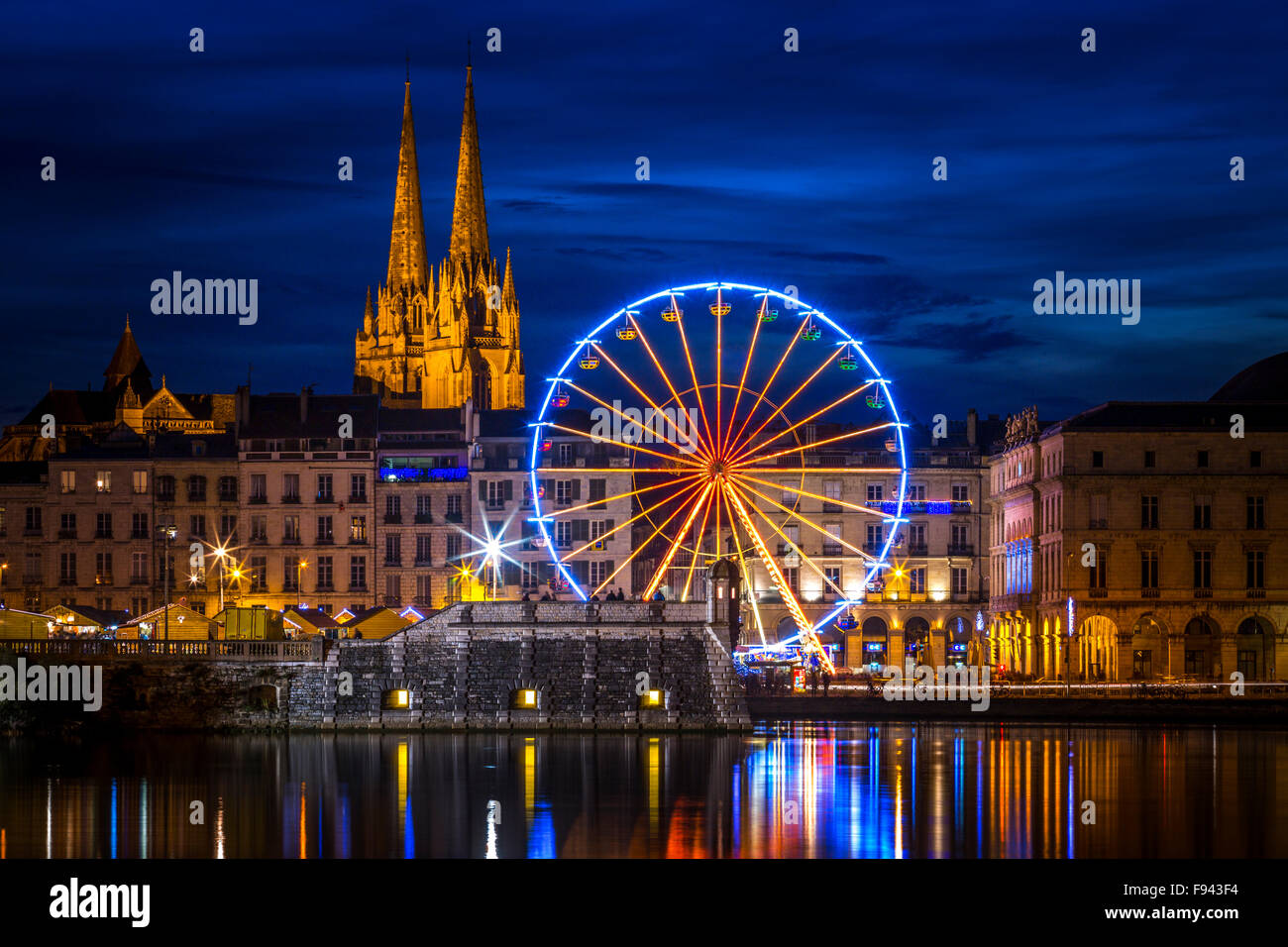 At night, a big wheel (Ferris Wheel) reflecting in water at the Adour ...
