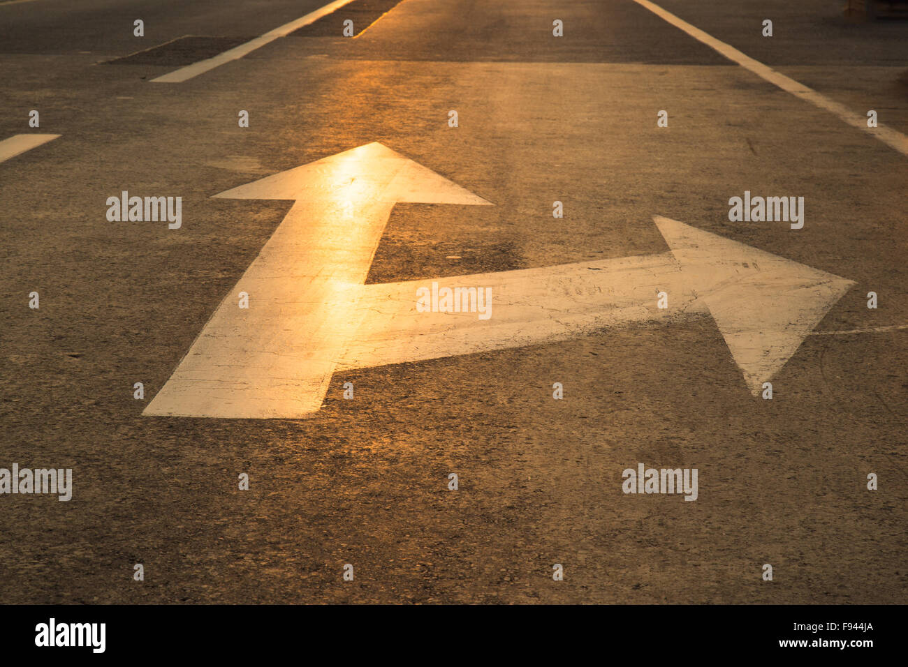 Straight and right street arrows at sunset Stock Photo - Alamy