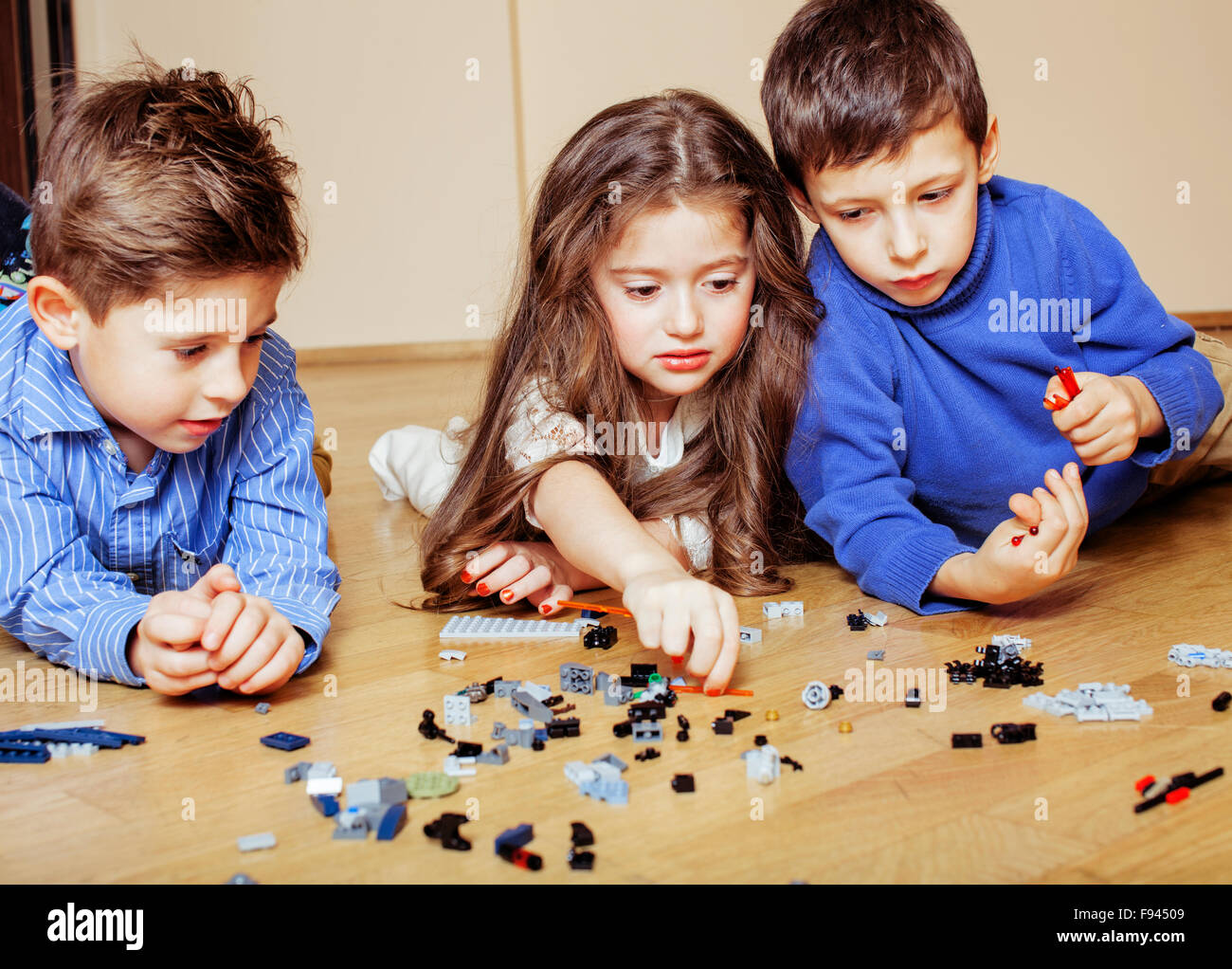 funny cute children playing lego at home, boys and girl smiling, first ...