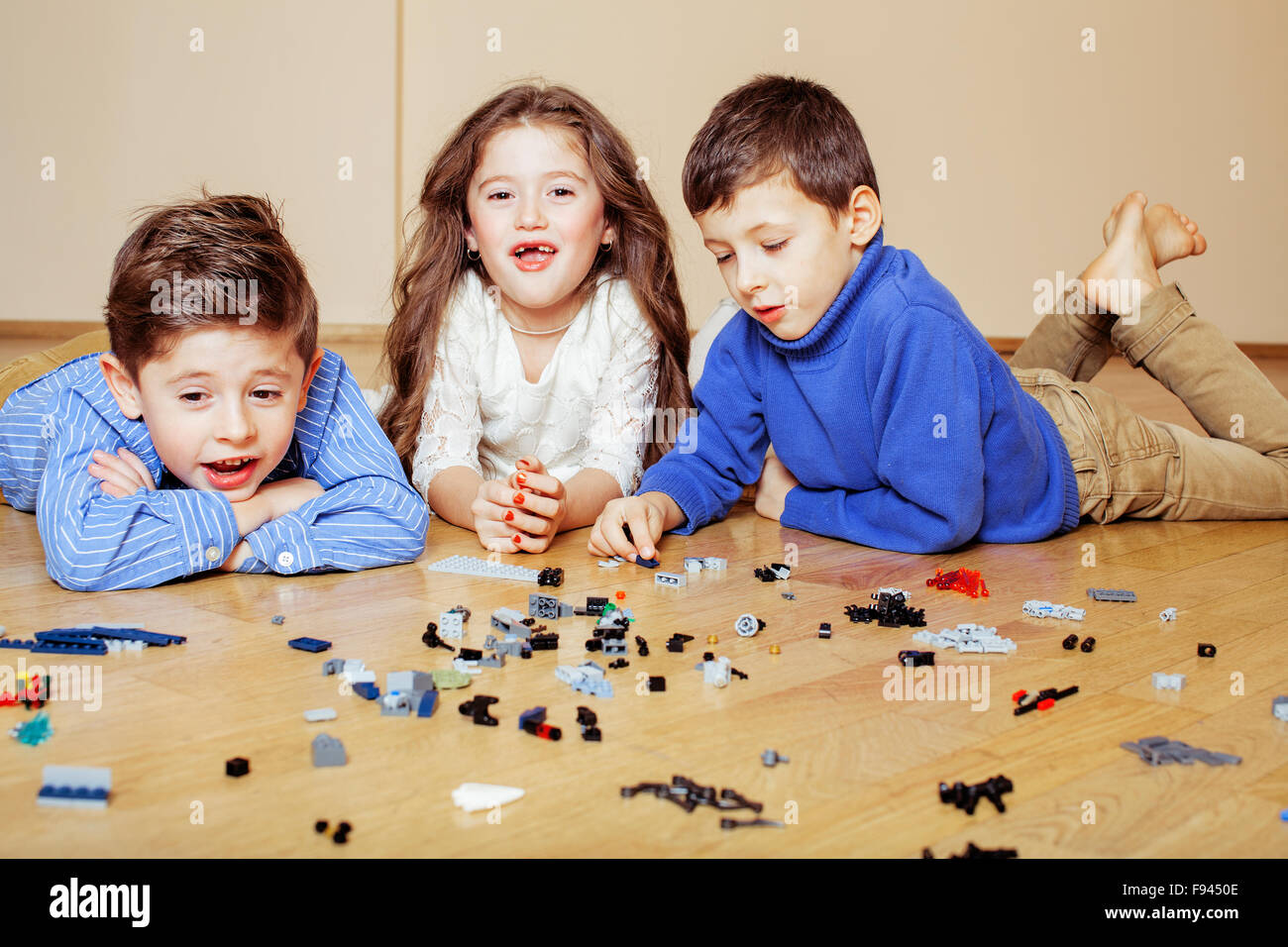 funny cute children playing lego at home, boys and girl smiling, first ...