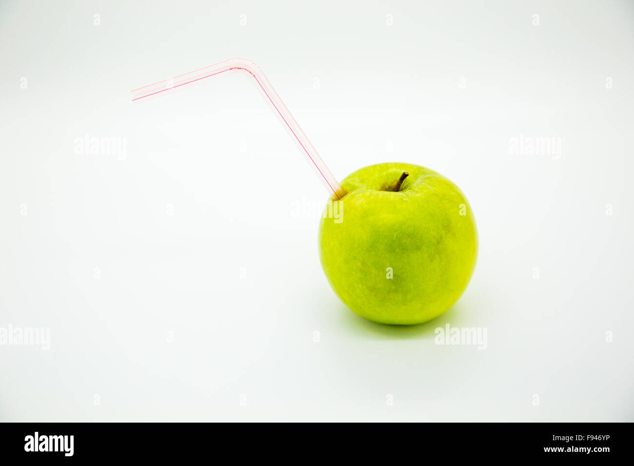 Apple with straw inside Stock Photo - Alamy