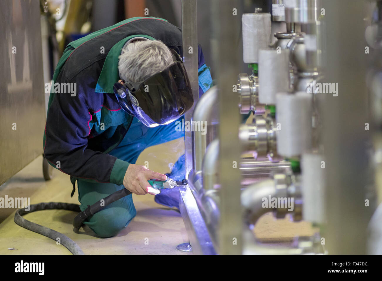Industrial worker welding in metal factory Stock Photo - Alamy