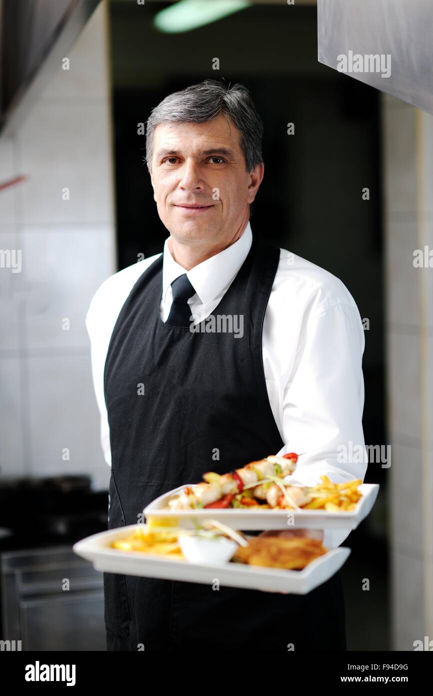 male chef presenting food meal in kitchen Stock Photo - Alamy